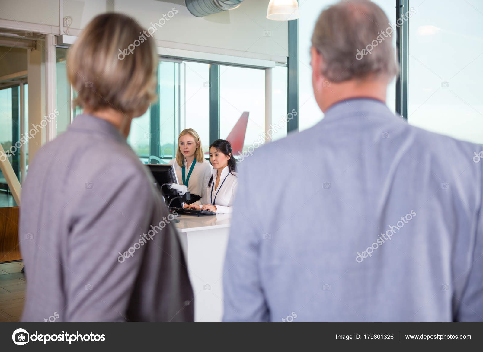 Receptionists Using Computer While Senior Business Couple Waitin ...