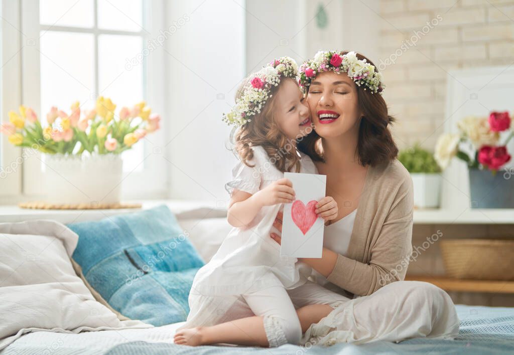 ¡Feliz día de la madre! Un niño felicitando a mamá. Mamá y su hija ...