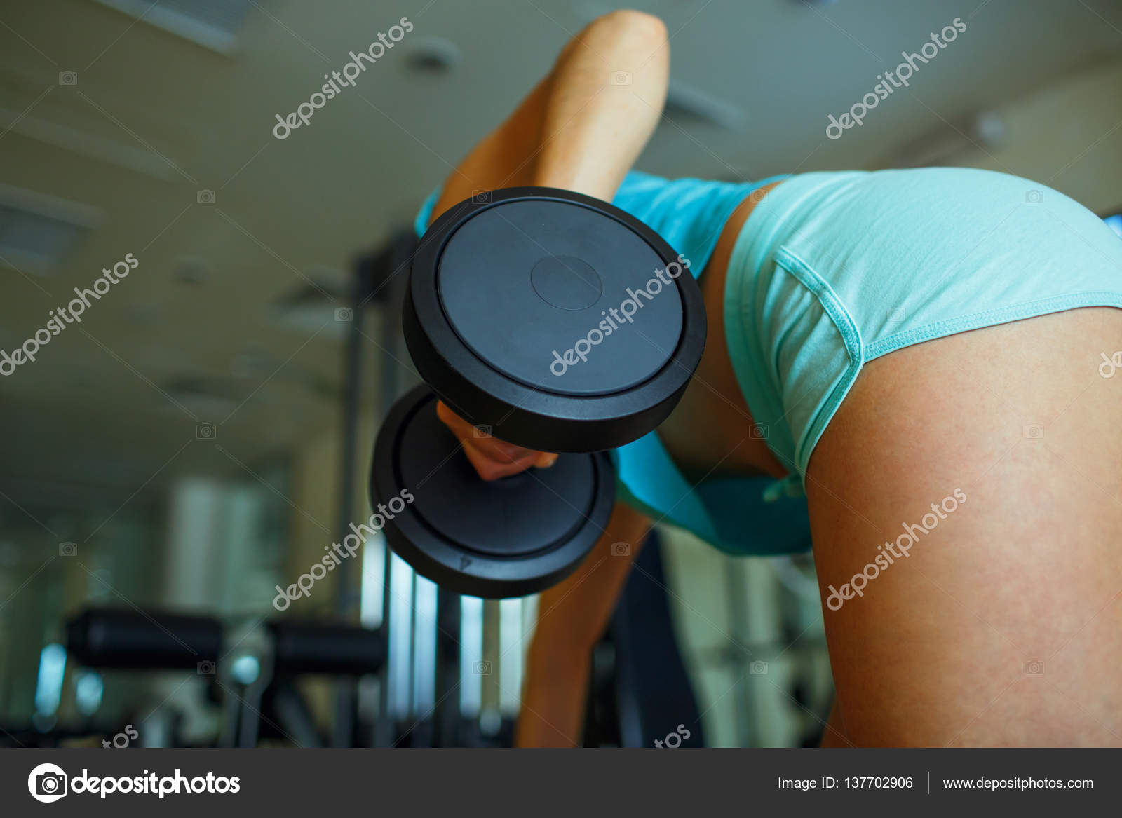 Woman with dumbbells in the gym doing sport exercises Stock Photo by ©vlad_star 137702906