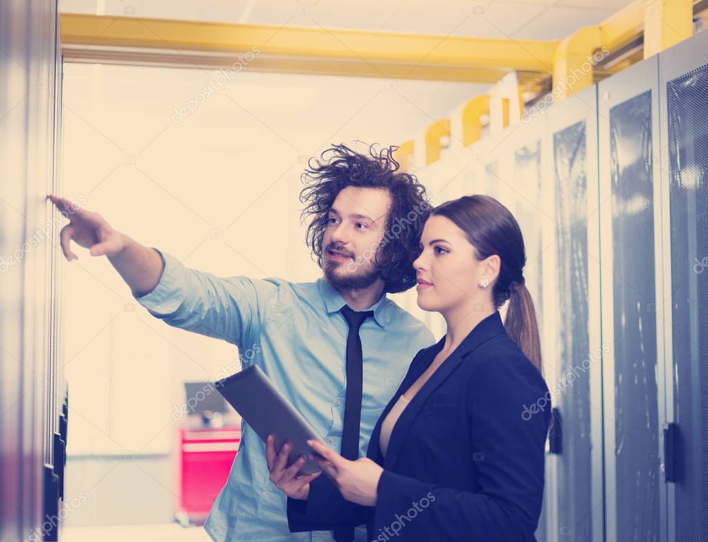 Ingeniero de TI joven que muestra la sala de servidores del centro de ...