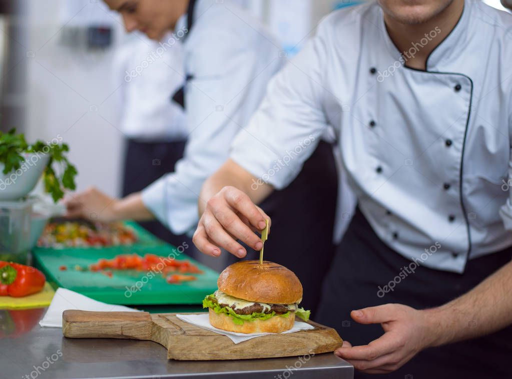 chef principal poner palillo de dientes en una hamburguesa en la cocina ...