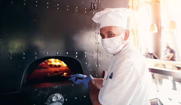 Skilled chef preparing traditional italian pizza in interior of modern ...