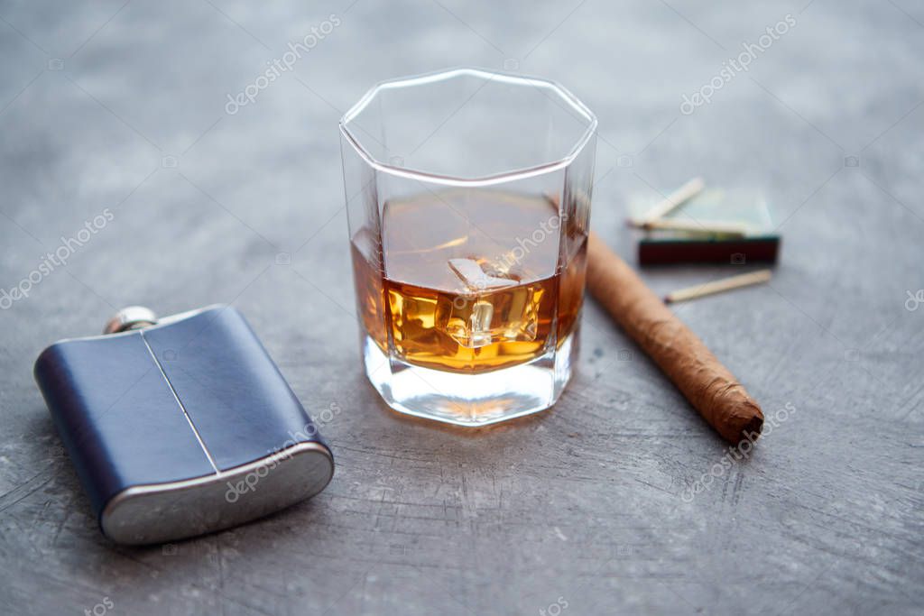 Vaso de whisky con hielo, cigarro cubano grande, cerillas y frasco de ...