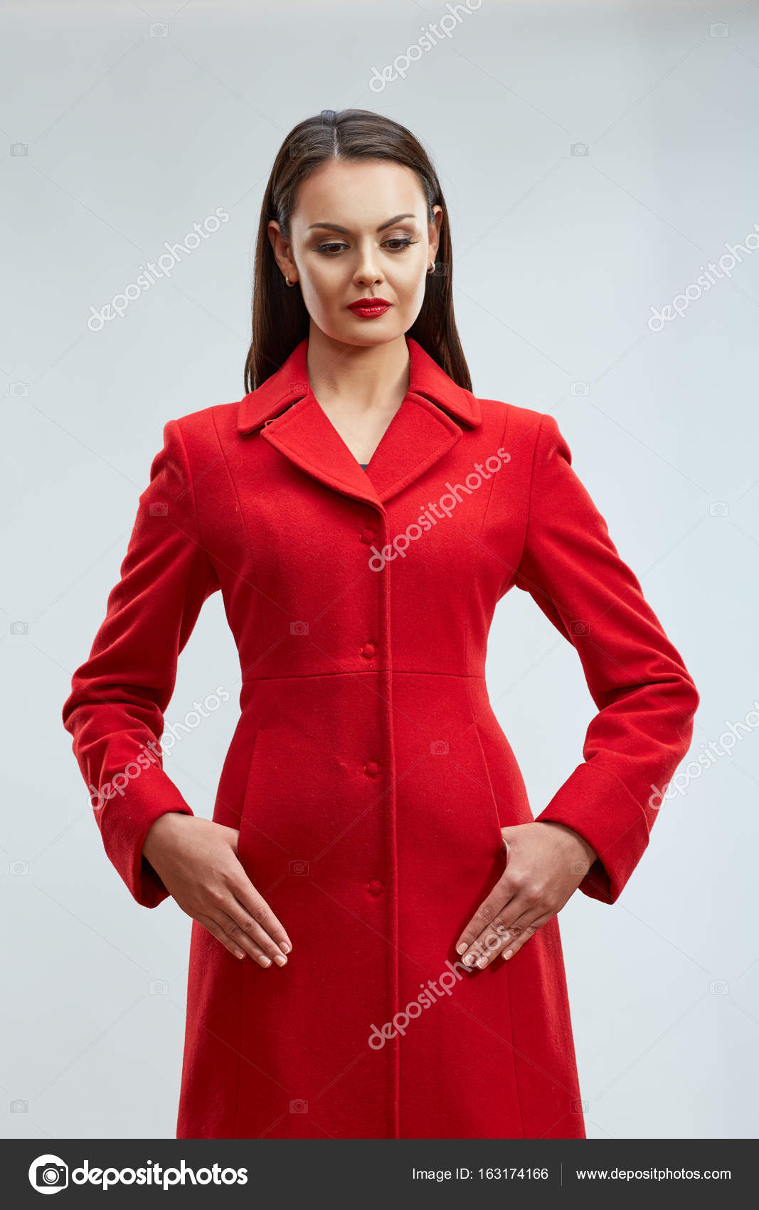 Fashion model posing in red coat against isolated studio backgro Stock ...