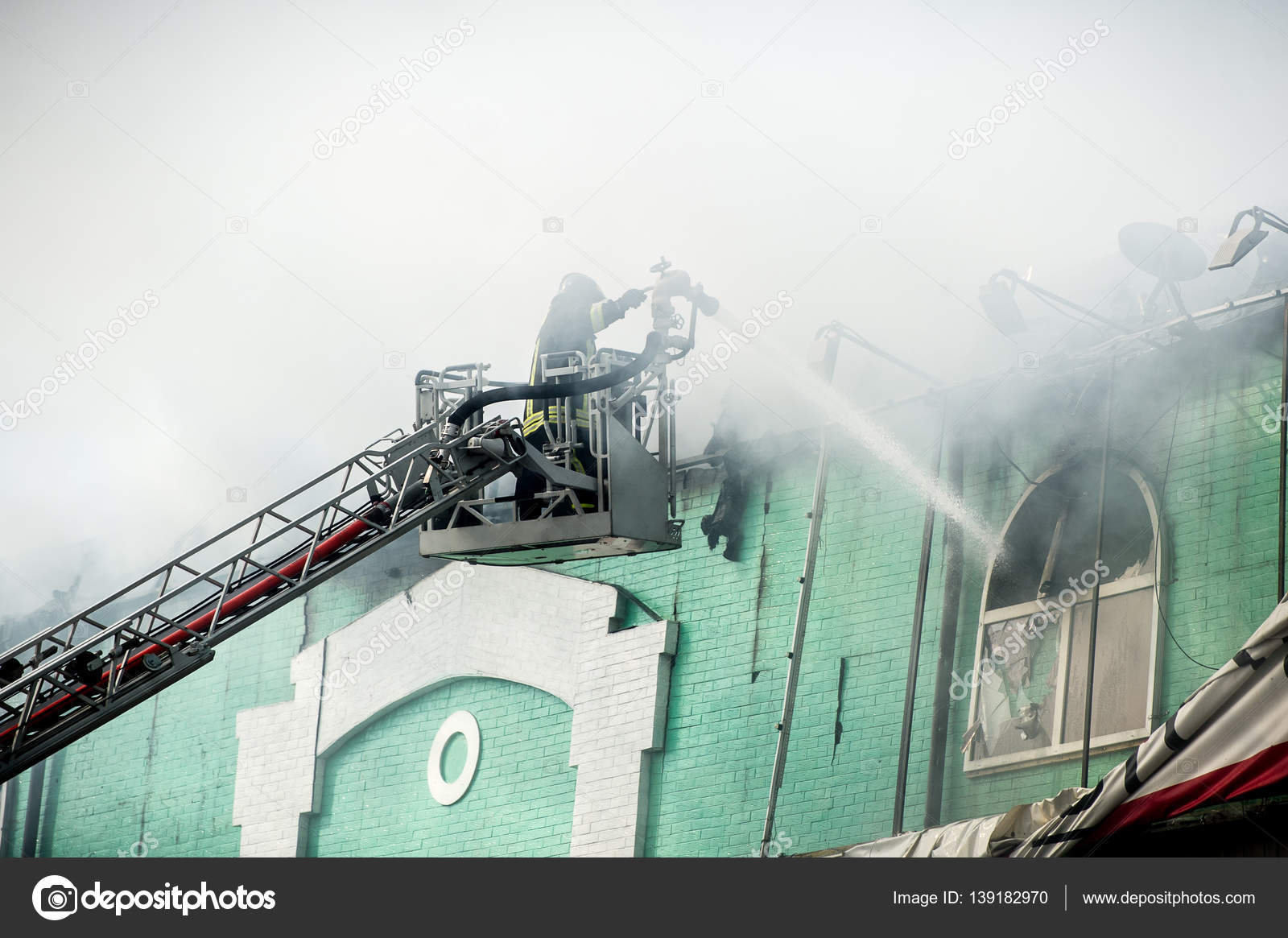 Firefighters in action fighting, extinguishing fire, in smoke. — Stock ...