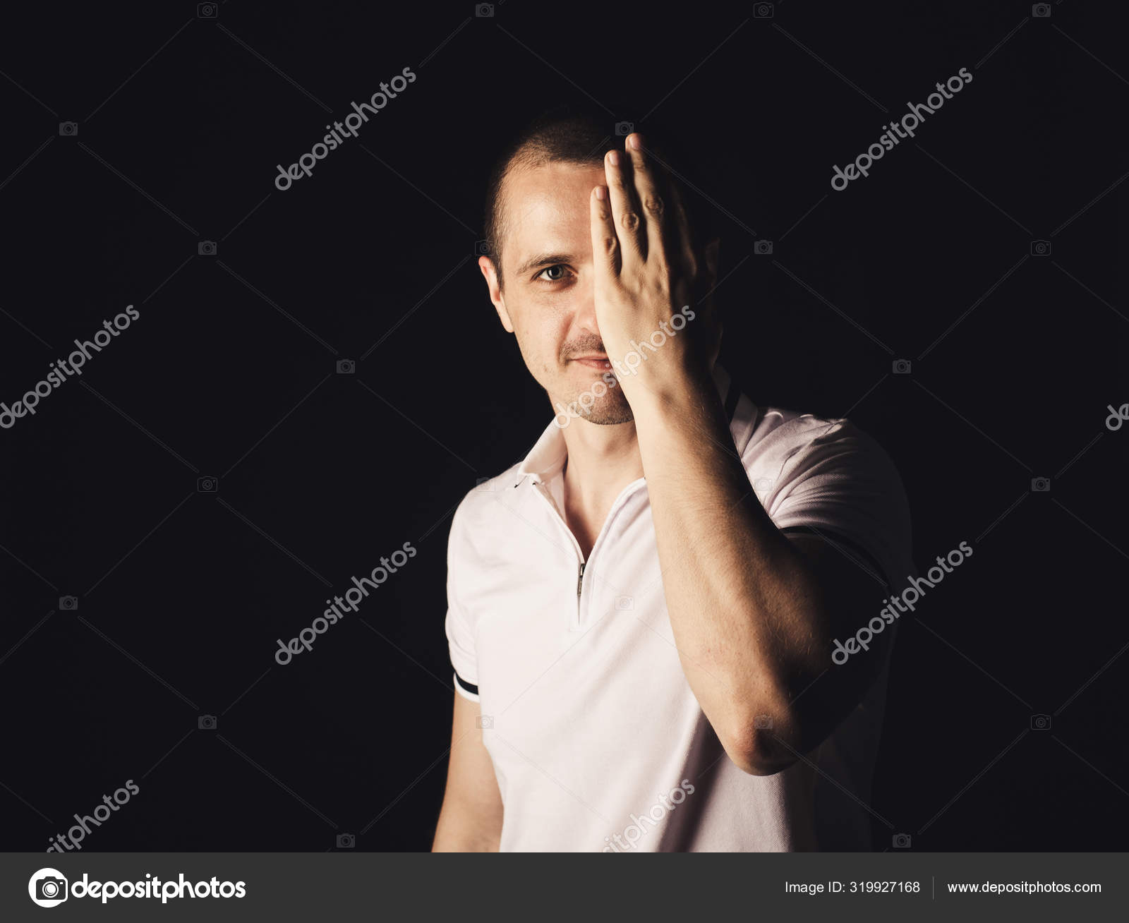 Man with half closed face by hand looking in camera Stock Photo by ...