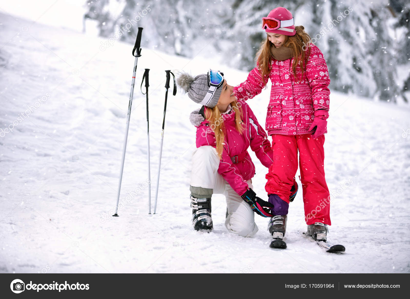 Mother fixing pants to daughter on ski terrain — Stock Photo ...
