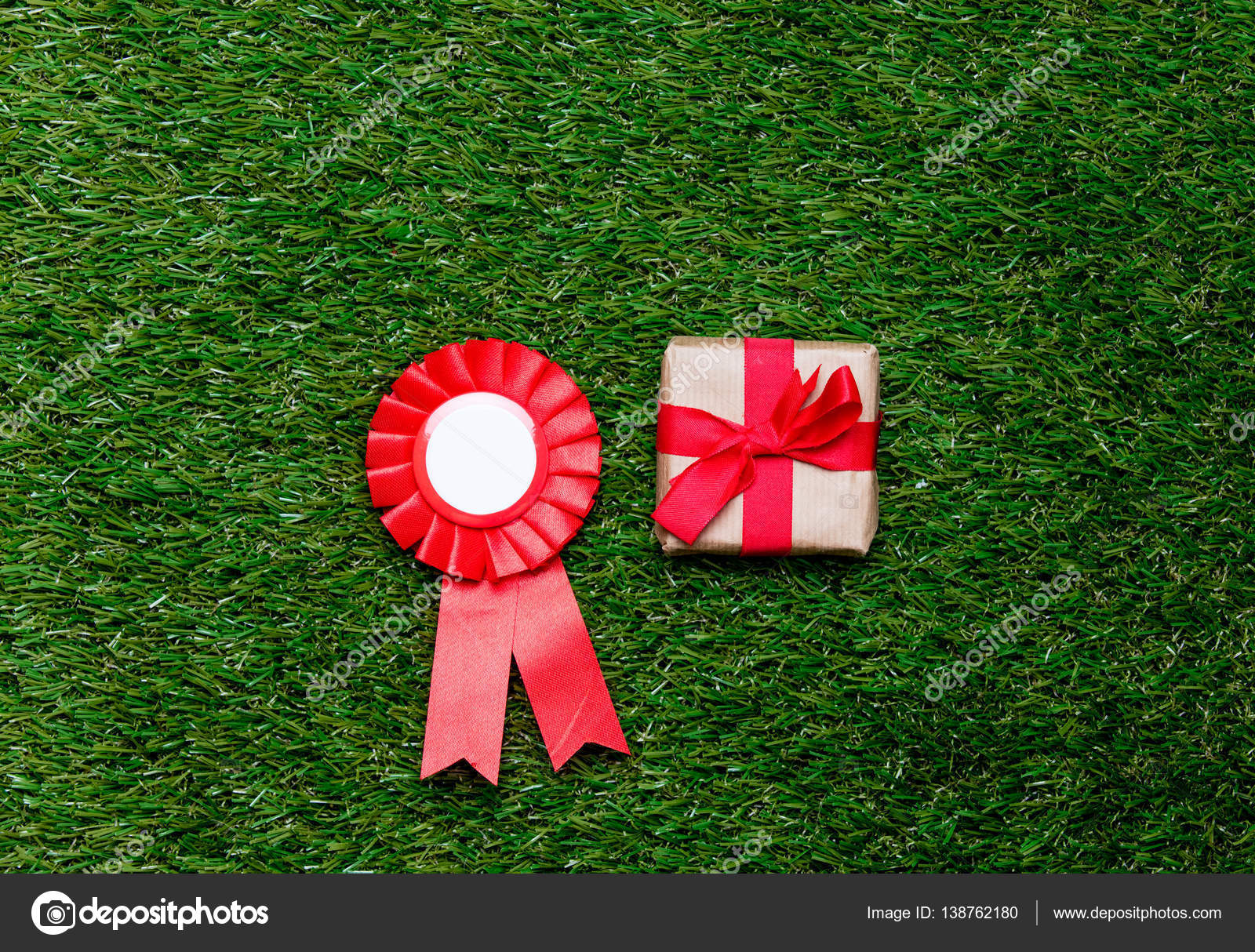 Red reward and gift box on green grass background, Stock Photo by ...