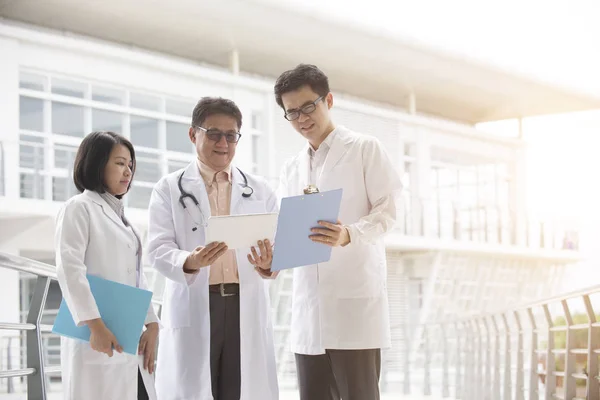 asian medical team outdoor by modern clinic - Stock Image - Everypixel