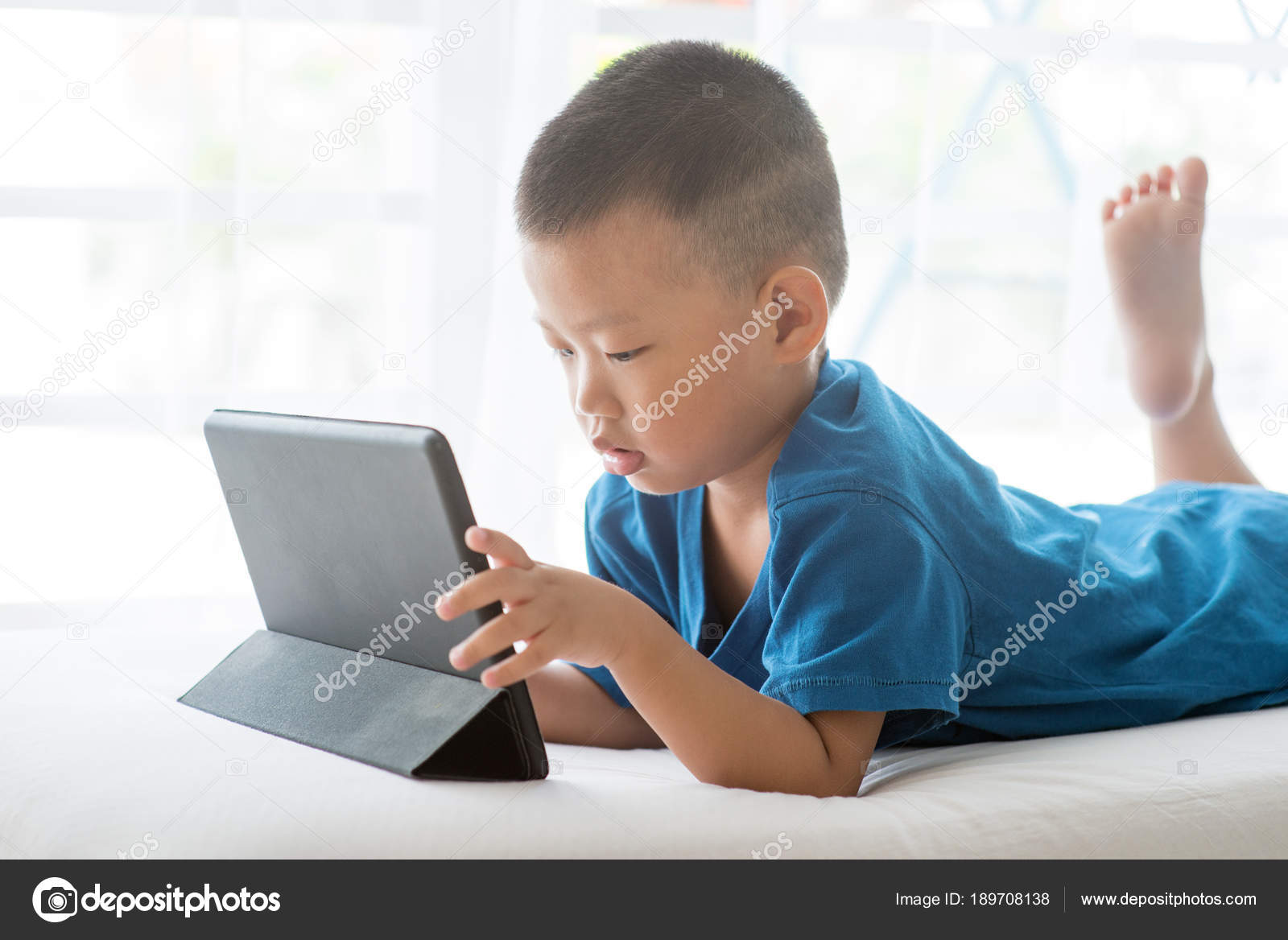 Child addicted to tablet. — Stock Photo © szefei #189708138