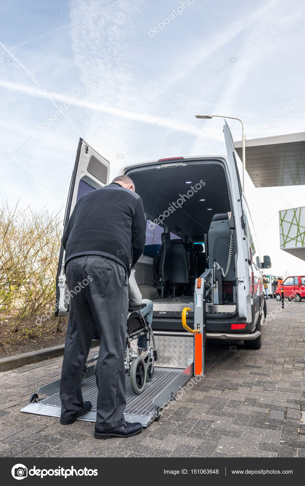 Driver assisting man on wheelchair — Stock Photo © Corepics #151063648
