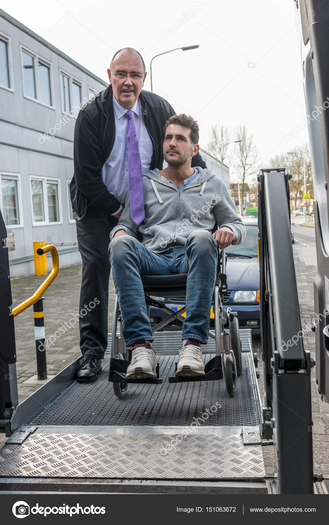 Driver helping man on wheelchair Stock Photo by ©Corepics 151063672