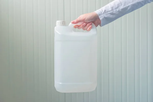 White plastic tank canister in female hand - Stock Image - Everypixel