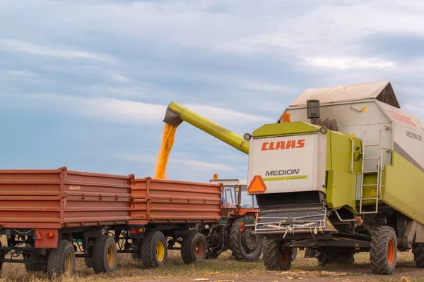 Combine harvester unloading harvested corn into tractor trailer – Stock ...