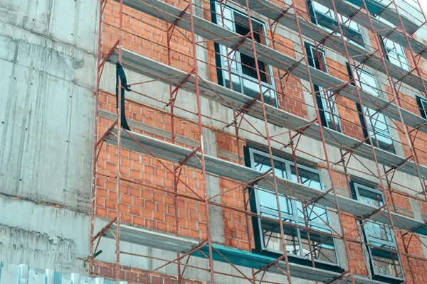 Scaffolding around new unrendered building at construction site Stock ...
