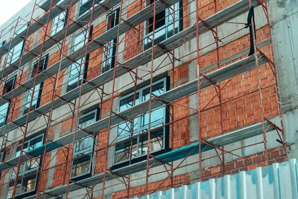Scaffolding around new unrendered building at construction site Stock ...