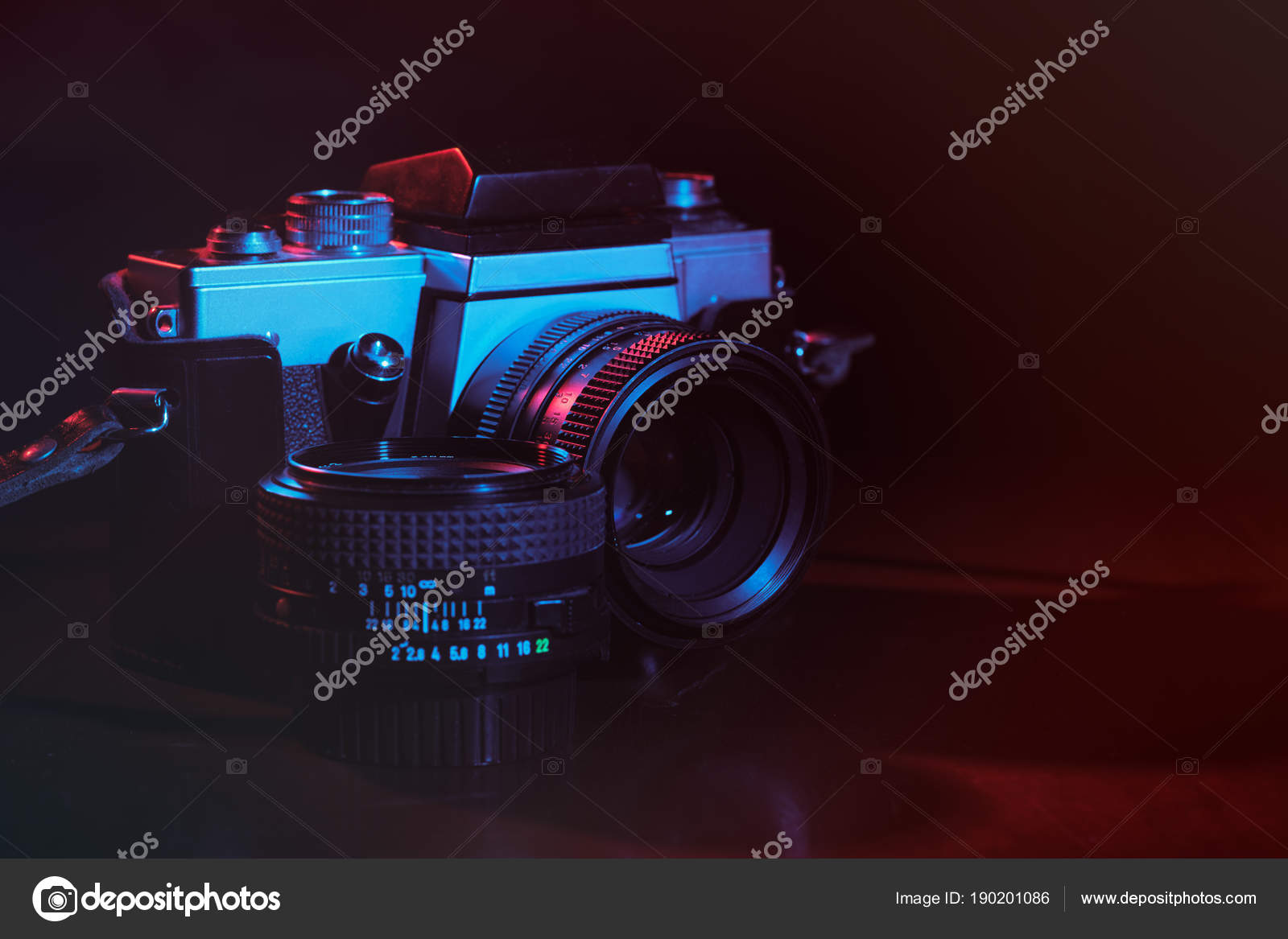Vintage film camera and lenses illuminated in red and blue shade ...