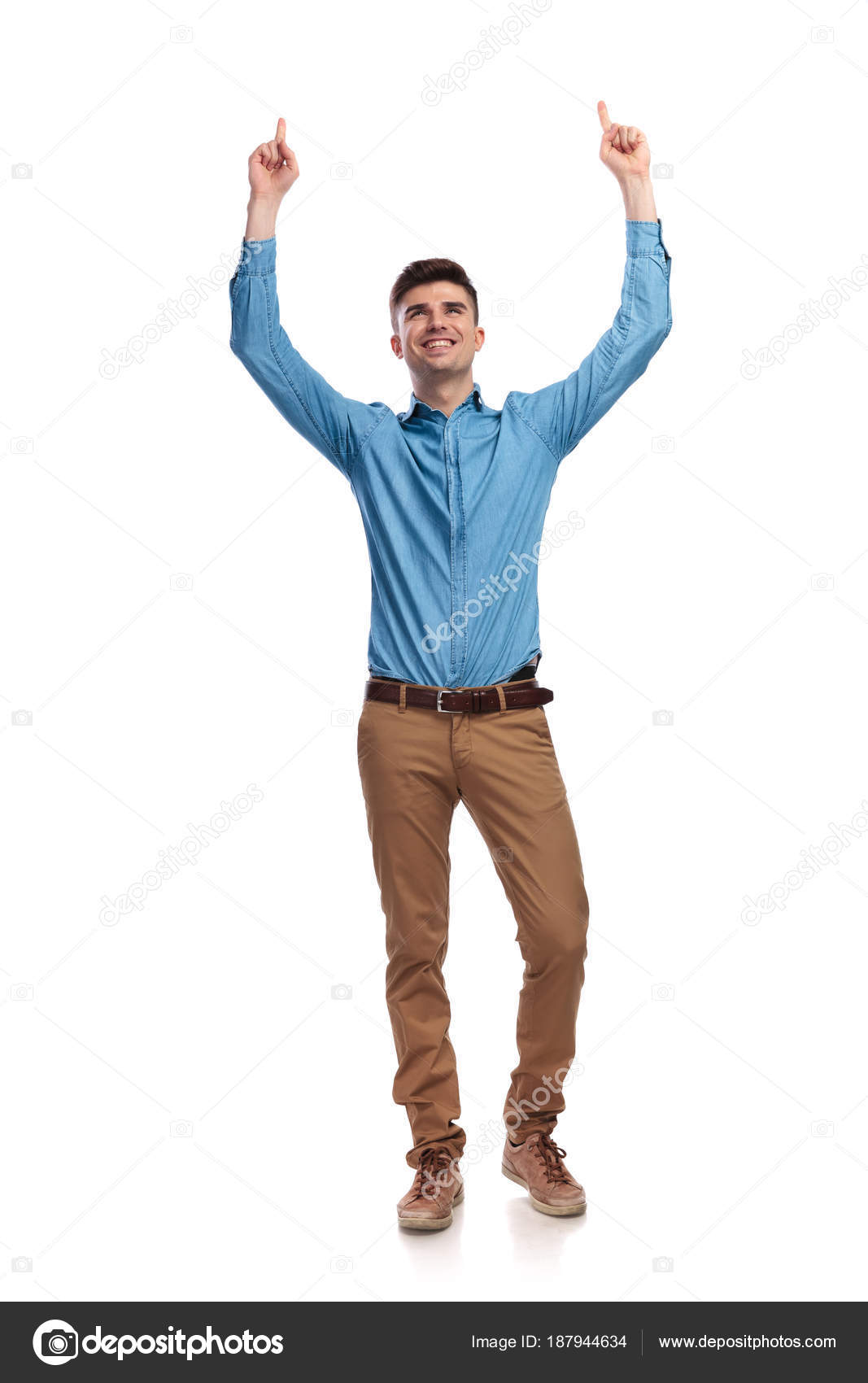Casual man standing with hands in the air pointing up Stock Photo by ...