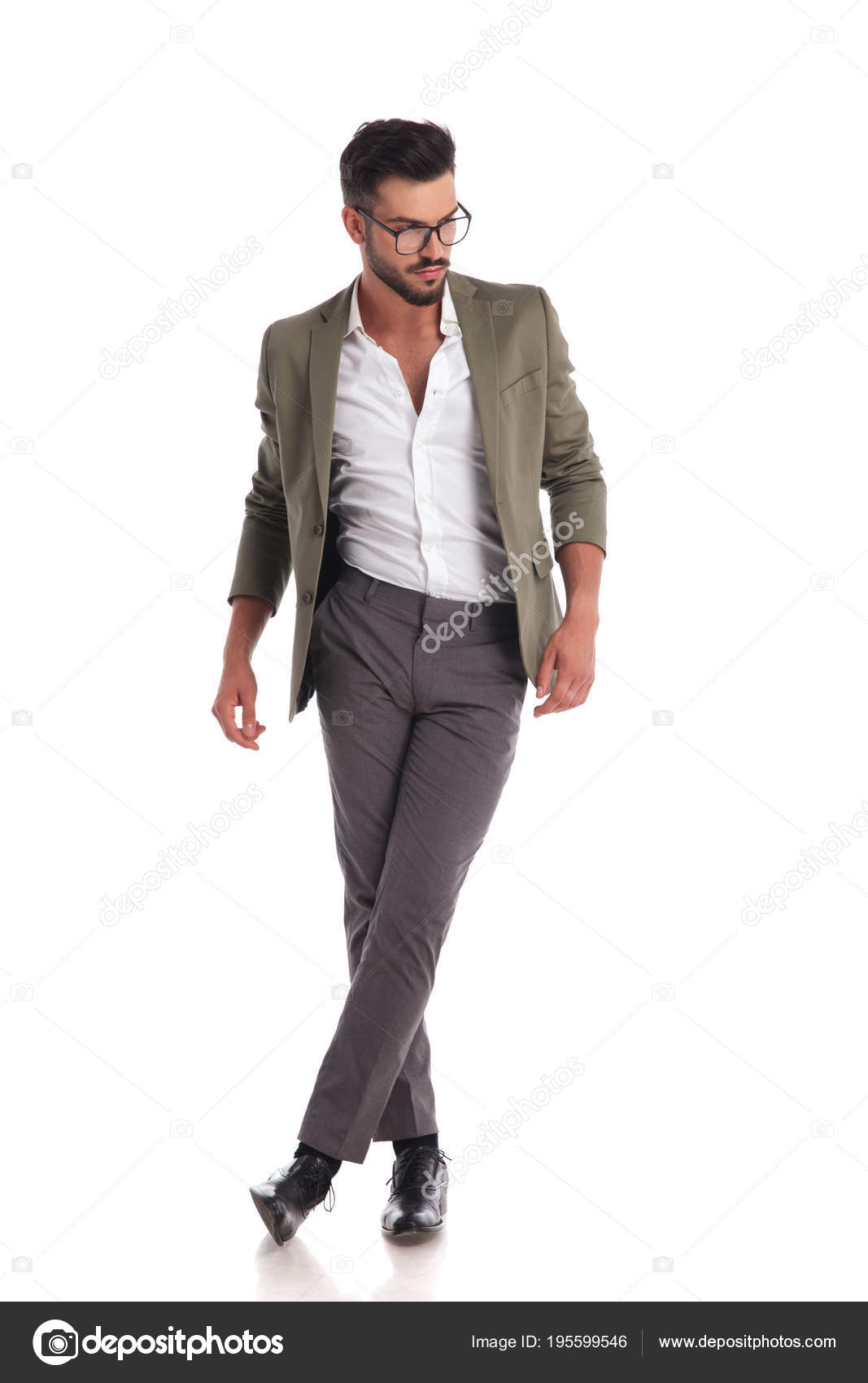 Young man standing wth legs crossed looks down to side Stock Photo by ...