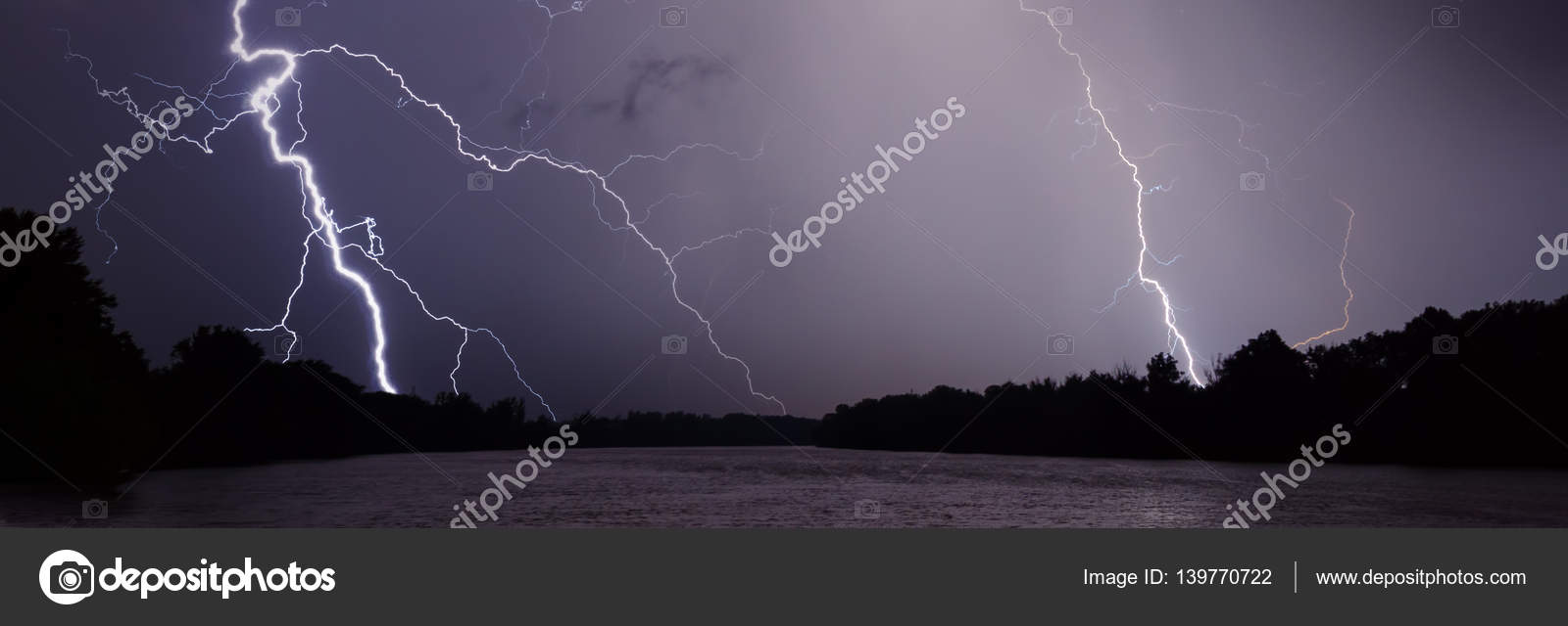 Thunder, lightnings and rain during storm over river and forest at ...