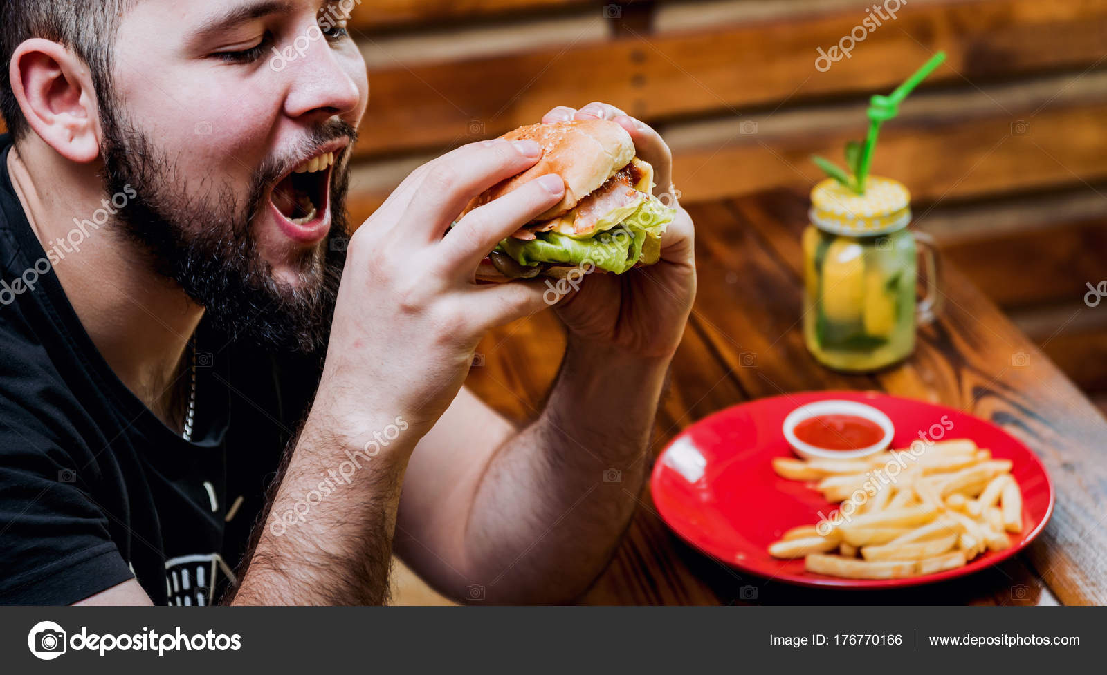 Young Man Eating Cheeseburger Restaurant Stock Photo by ©Romaset 176770166
