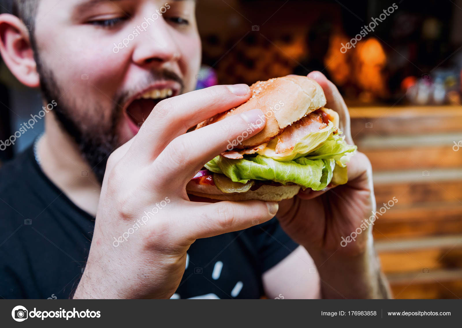 Young Man Eating Cheeseburger Restaurant Stock Photo by ©Romaset 176983858