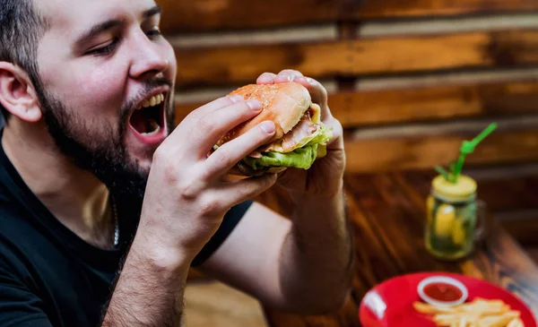 Young Man Eating Cheeseburger Restaurant Stock Photo by ©Romaset 176983858