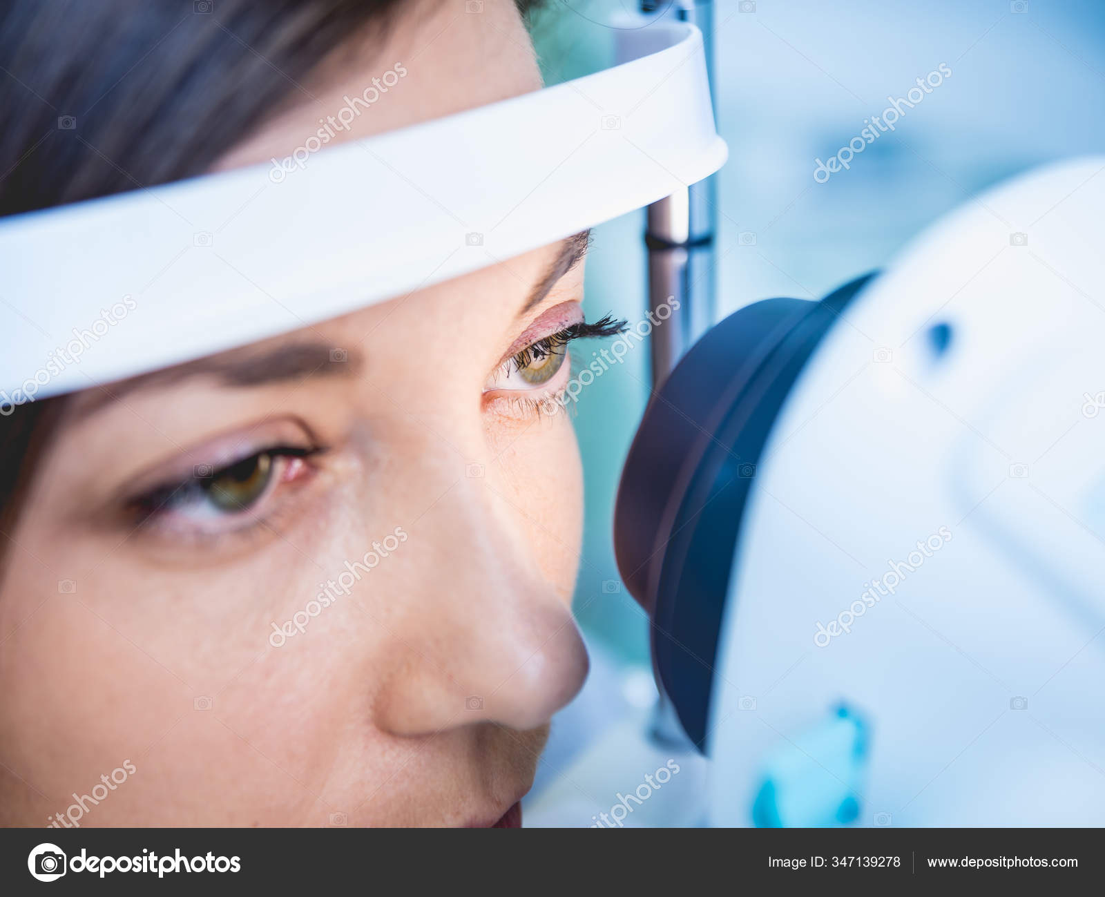 Doctor examinando los ojos de las mujeres con una máquina de medición ...