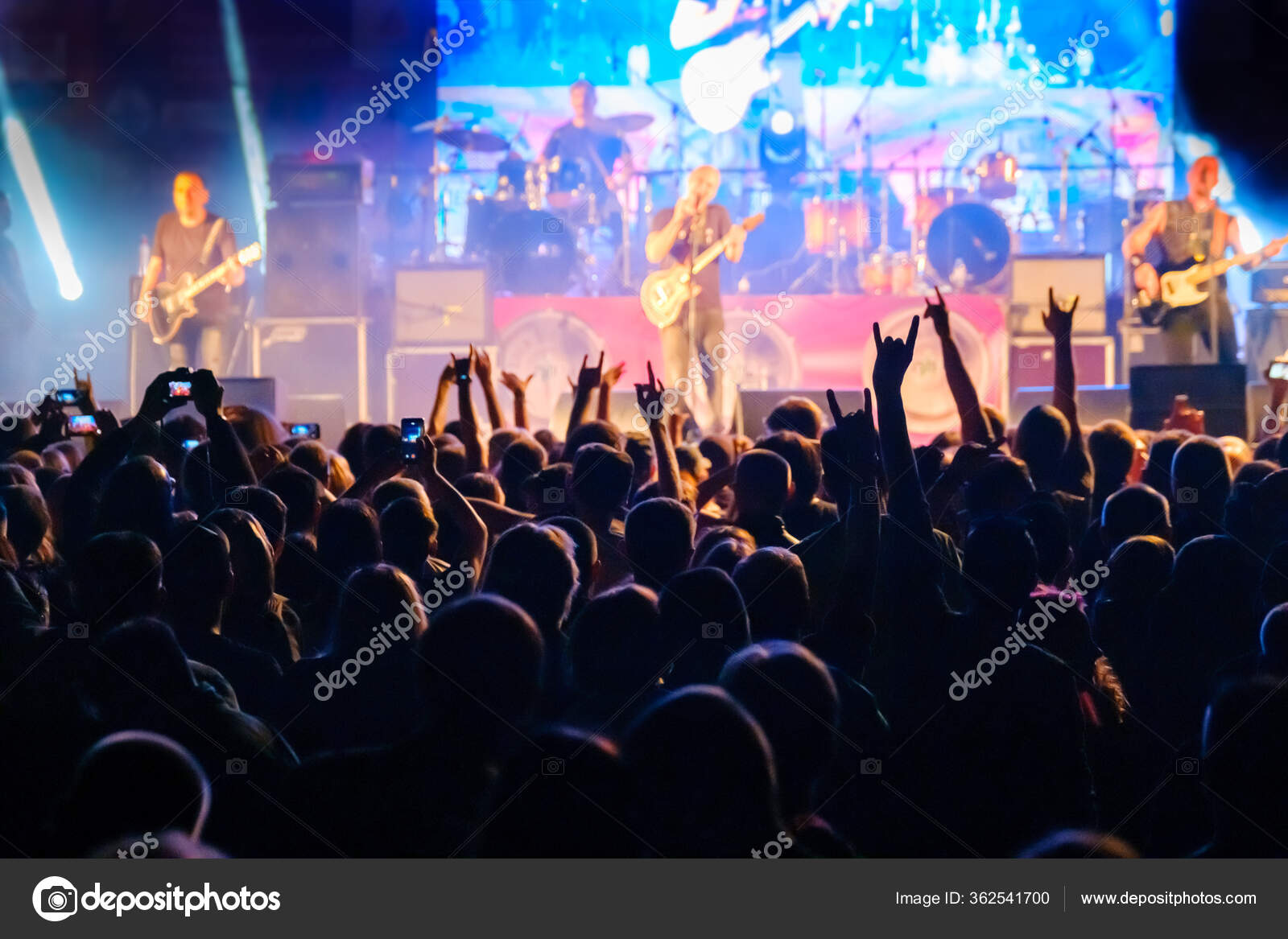 Fans in dark neon listening to rock band on stage — Stock Photo ...