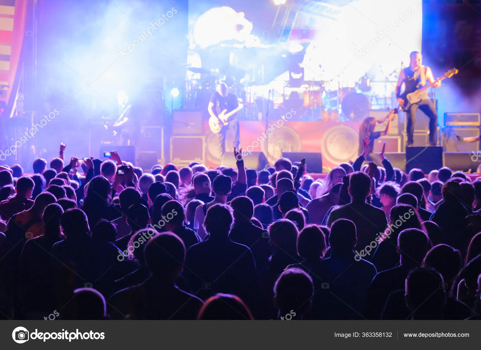 Fans in dark neon listening to rock band on stage — Stock Editorial ...