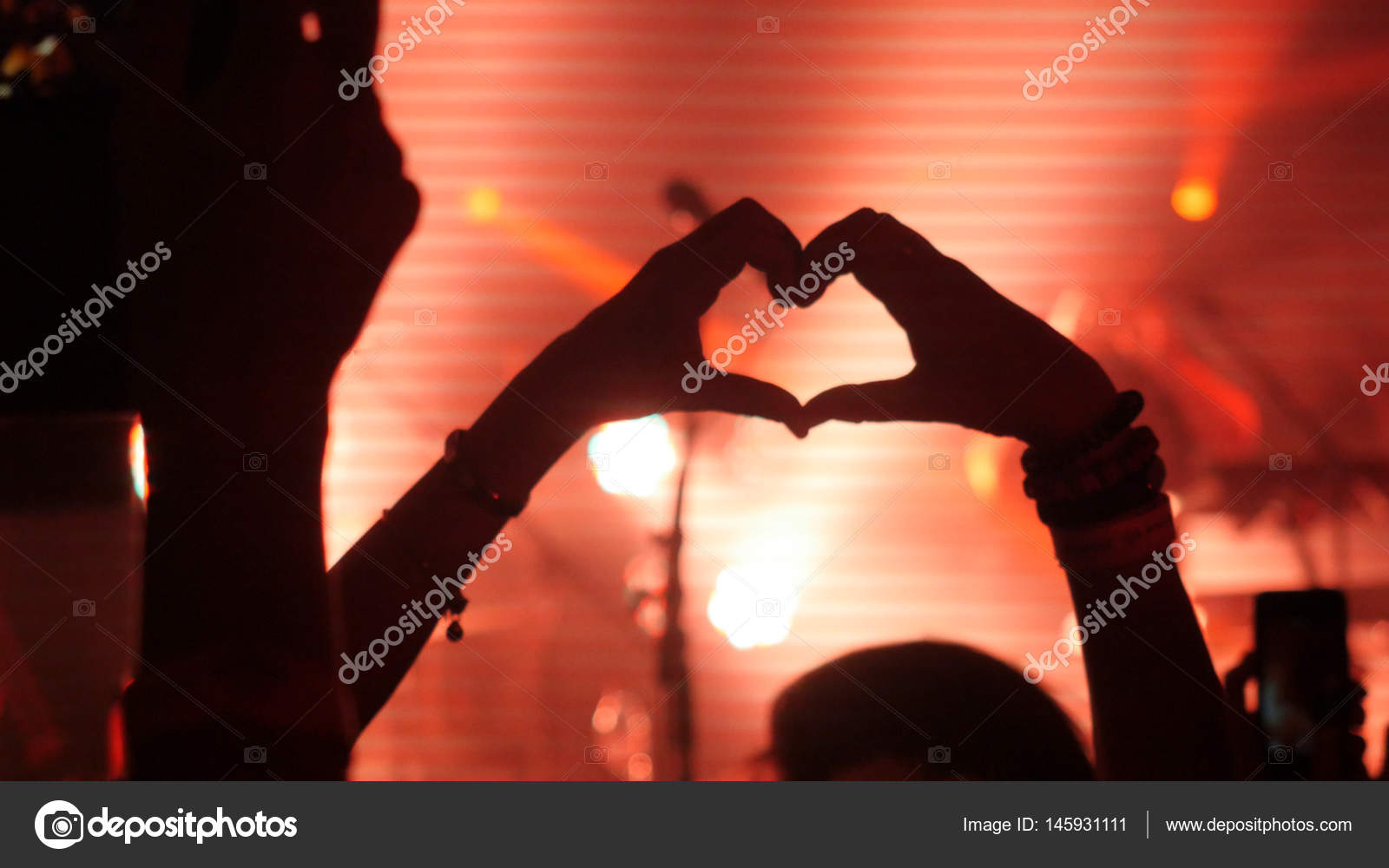 Fans making heart with hands at a rock concert in a night club. Stock ...