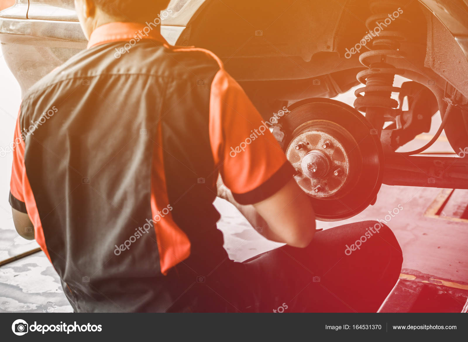 Professional car mechanic changing wheel in auto repair service. Stock ...