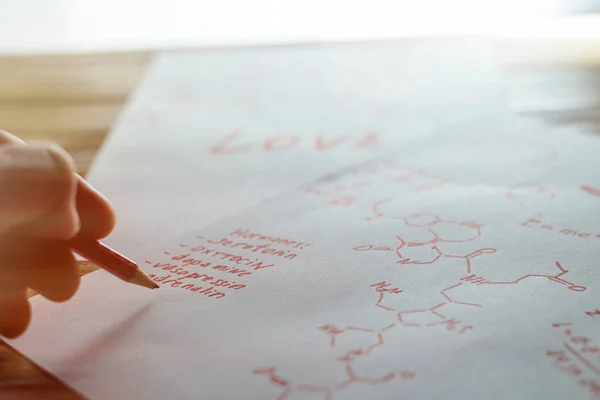 The concept of love as hormones. Sheets of paper written with formulas ...