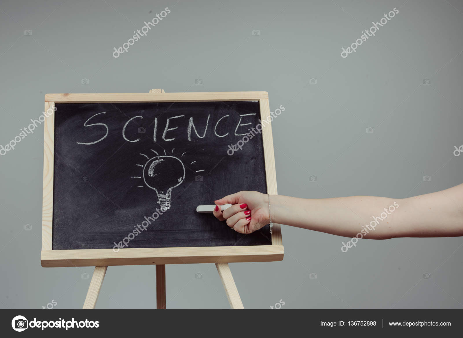 A teacher writing science, drawing chemistry elements on dark ...