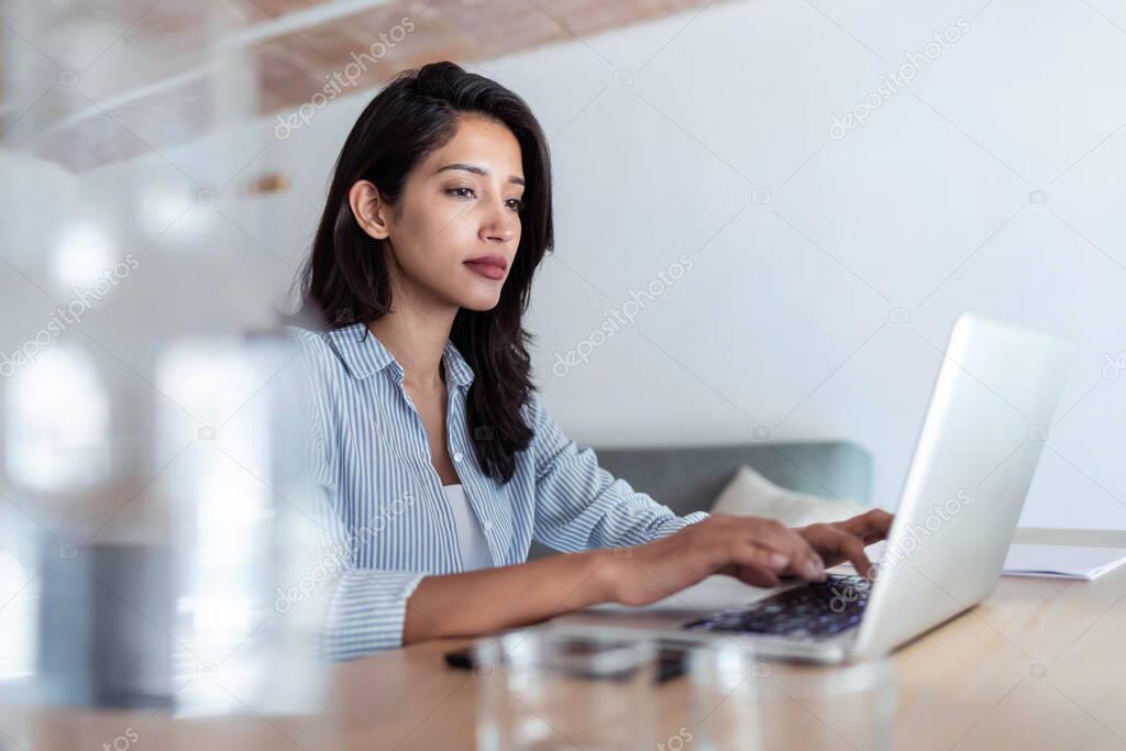 Foto de mujer de negocios joven y elegante que trabaja con su computadora portátil en la oficina ...