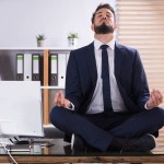 Female office worker meditating Stock Photo by ©DragonImages 52196009