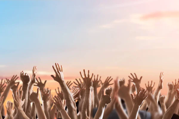 Multitud de personas levantando las manos en el evento de celebración 2023
