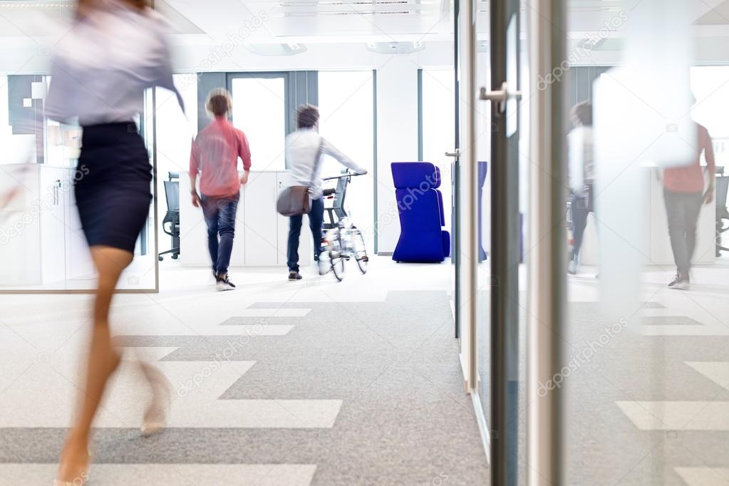 Businesswoman walking with colleagues at office Stock Photo by ...