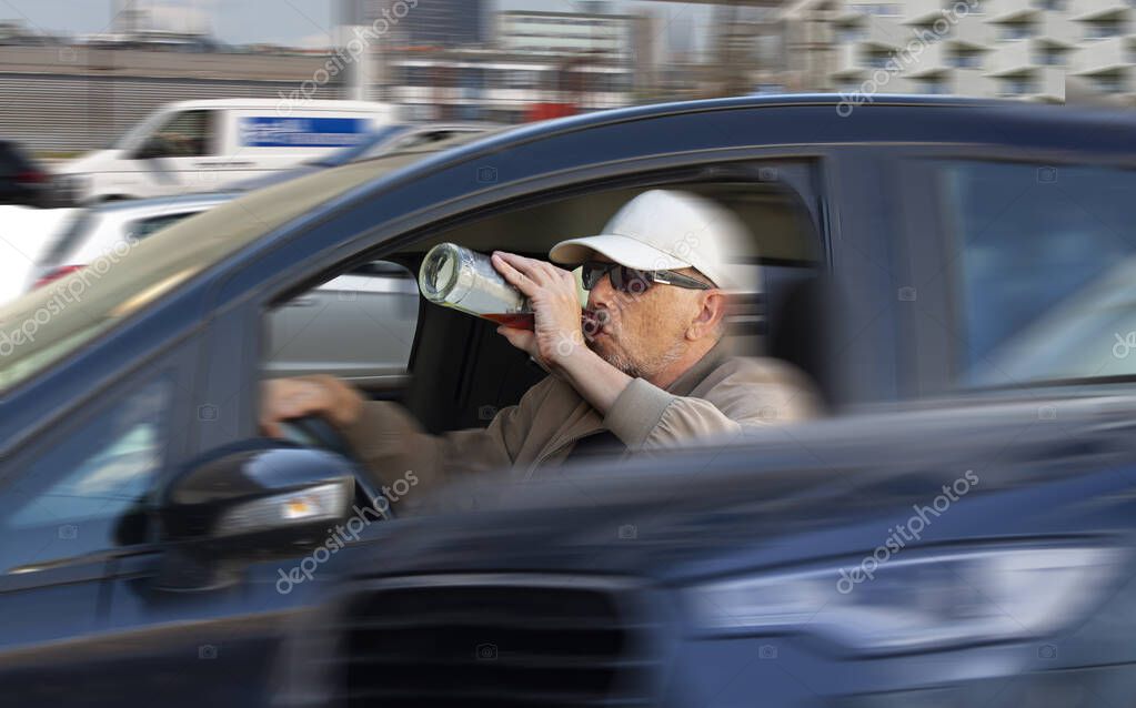 Conductor masculino descuidado con gafas de sol y gorra bebiendo licor ...