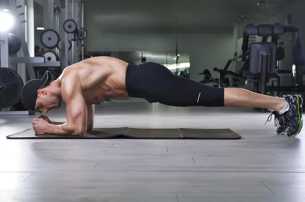 Handsome powerful athletic man doing plank exercise. Strong bodybuilder ...
