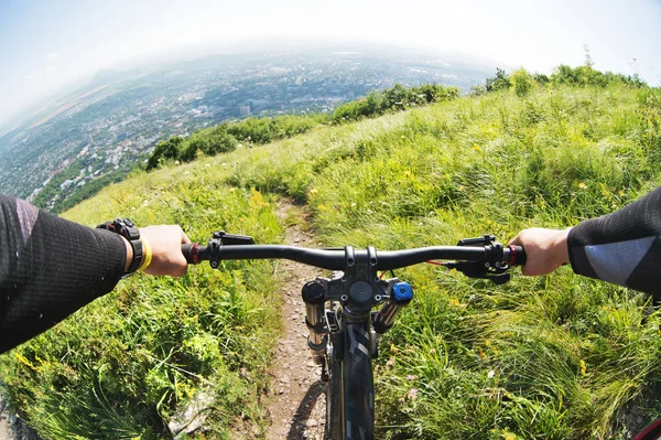 View from the first person of a cyclist riding downhill from a high ...