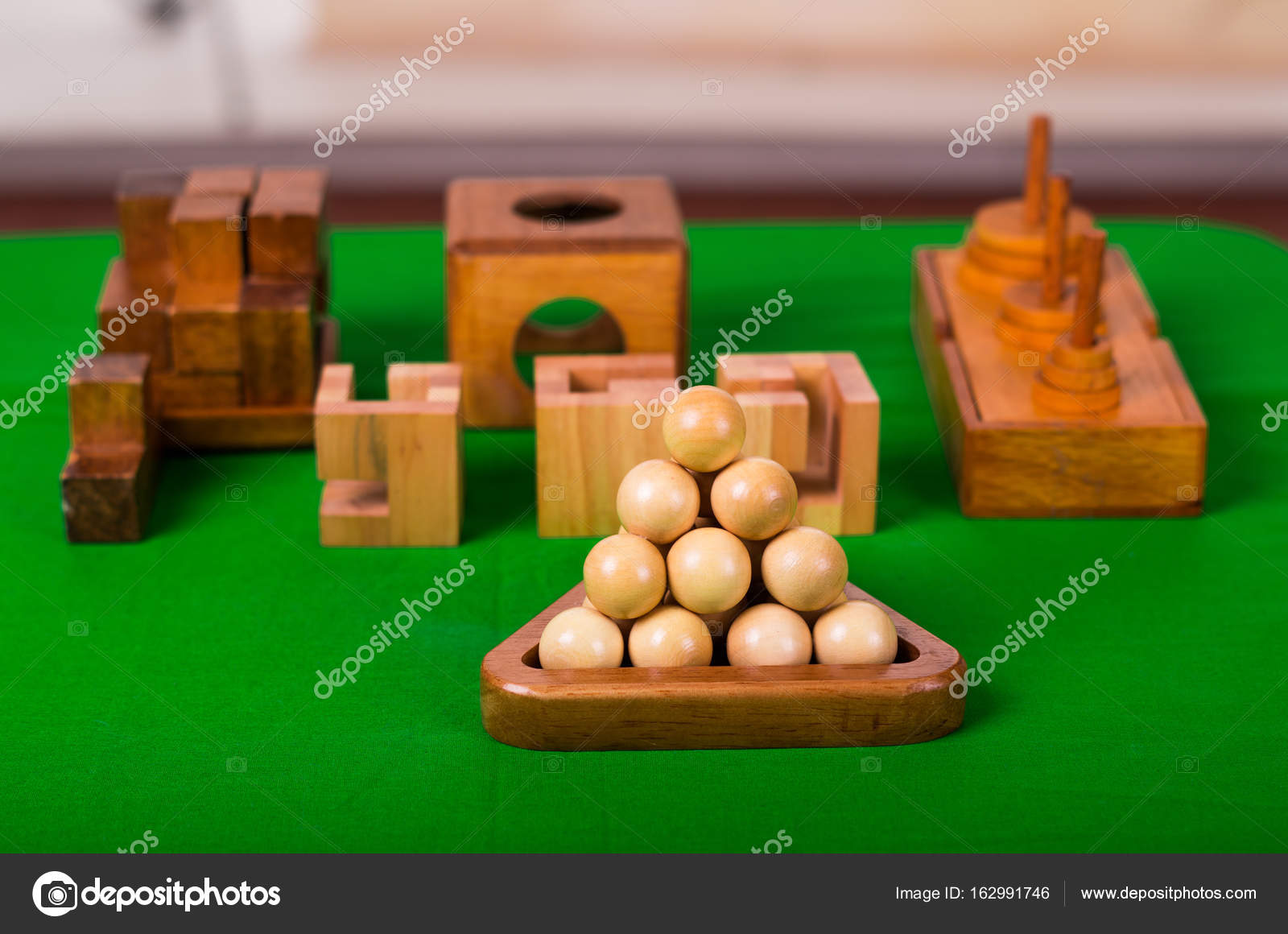 Assorted wooden brain teaser or wooden puzzles on green background ...