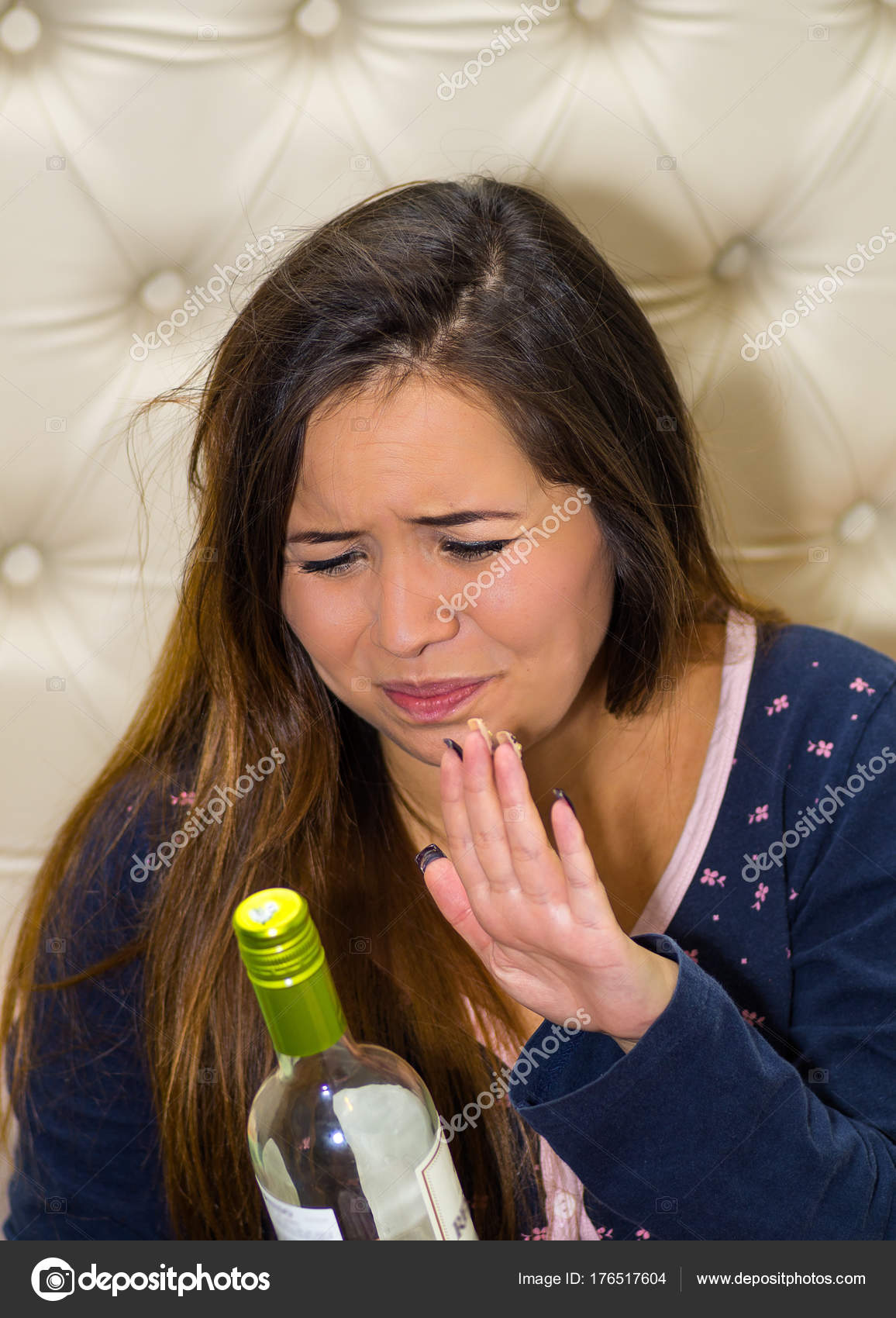 Drunk woman holding a bottle of alcohol and doing disgusting faces ...