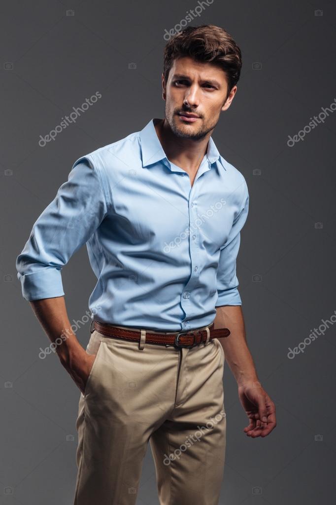 Handsome young man standing with hand in pocket Stock Photo by ...