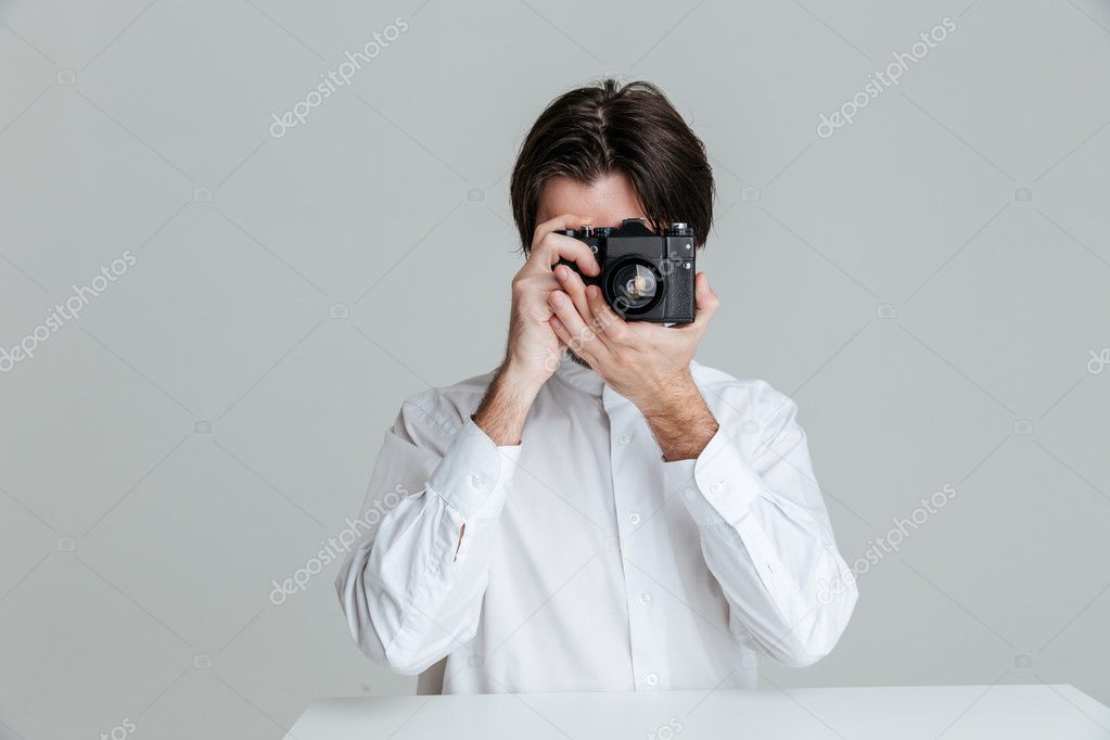 Man sitting at the table and making photo with camera Stock Photo by ...