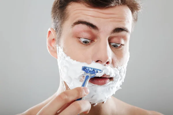 Close up portrait of a young man with shaving foam - Stock Image - Everypixel