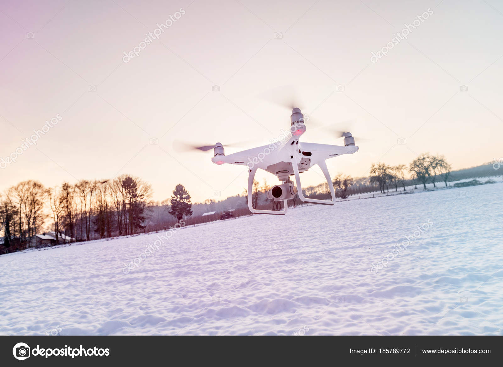 White drone camera floating in air with white snow and field in Stock ...