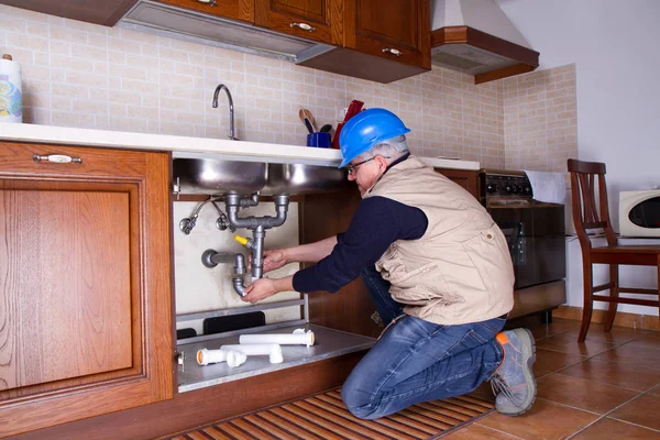 A plumber fixing a kitchen sink Stock Photo by ©monkeybusiness 106190348