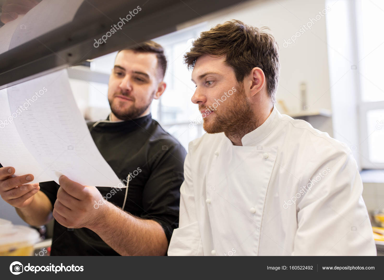 Chef and cook with lists or bills at kitchen Stock Photo by ©Syda ...