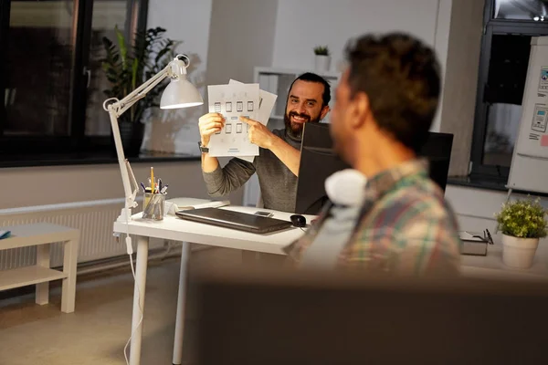 creative man showing papers to colleague at office - Stock Image ...